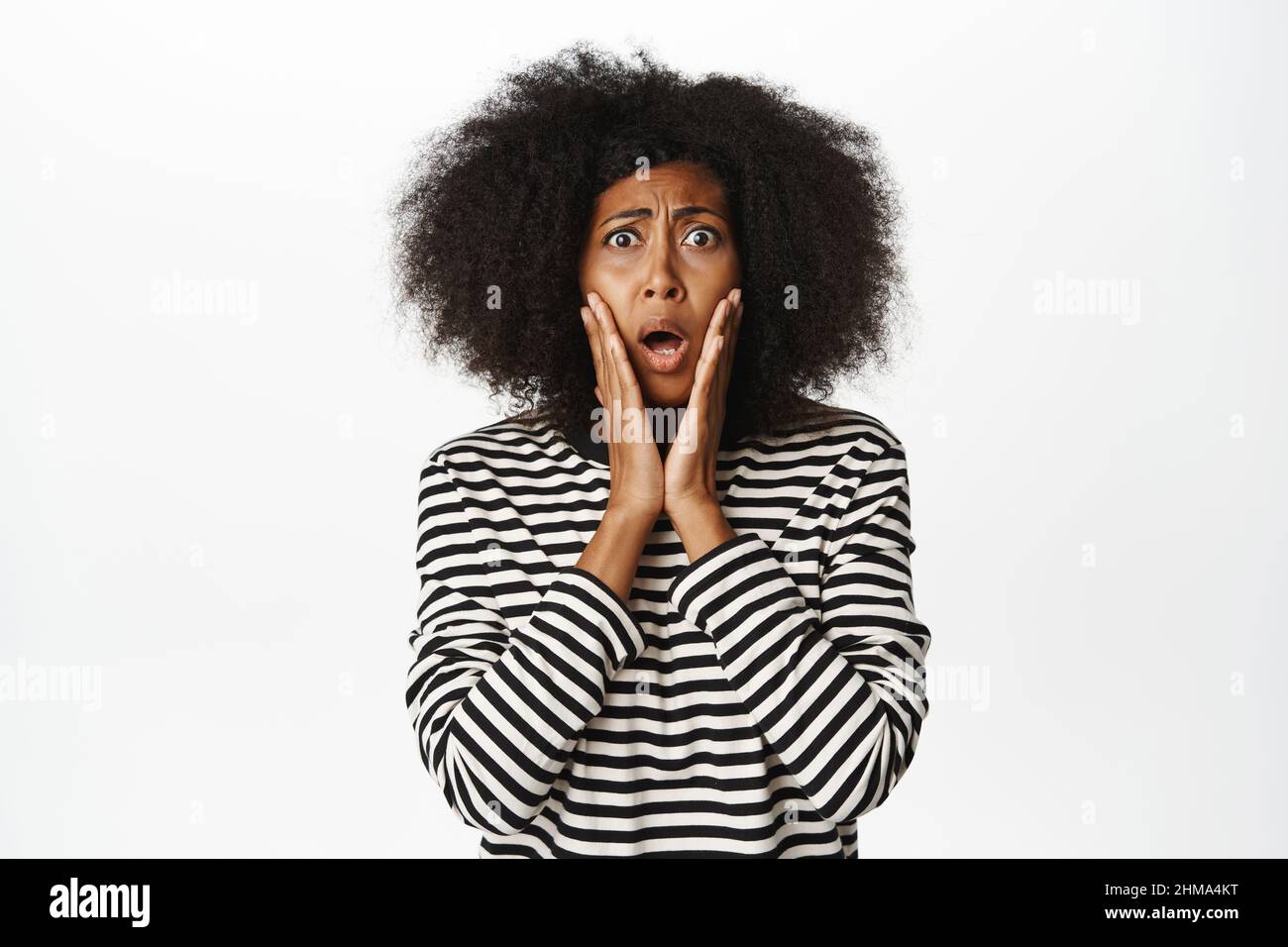 Shocked and concerned african woman gasping, looking terrified and ...