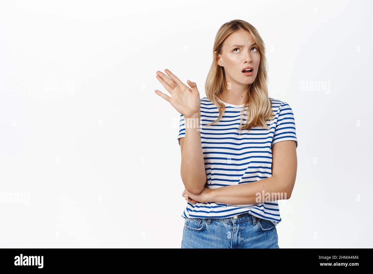 Enough, stop it. Unbothered and annoyed young woman roll eyes and wave ...