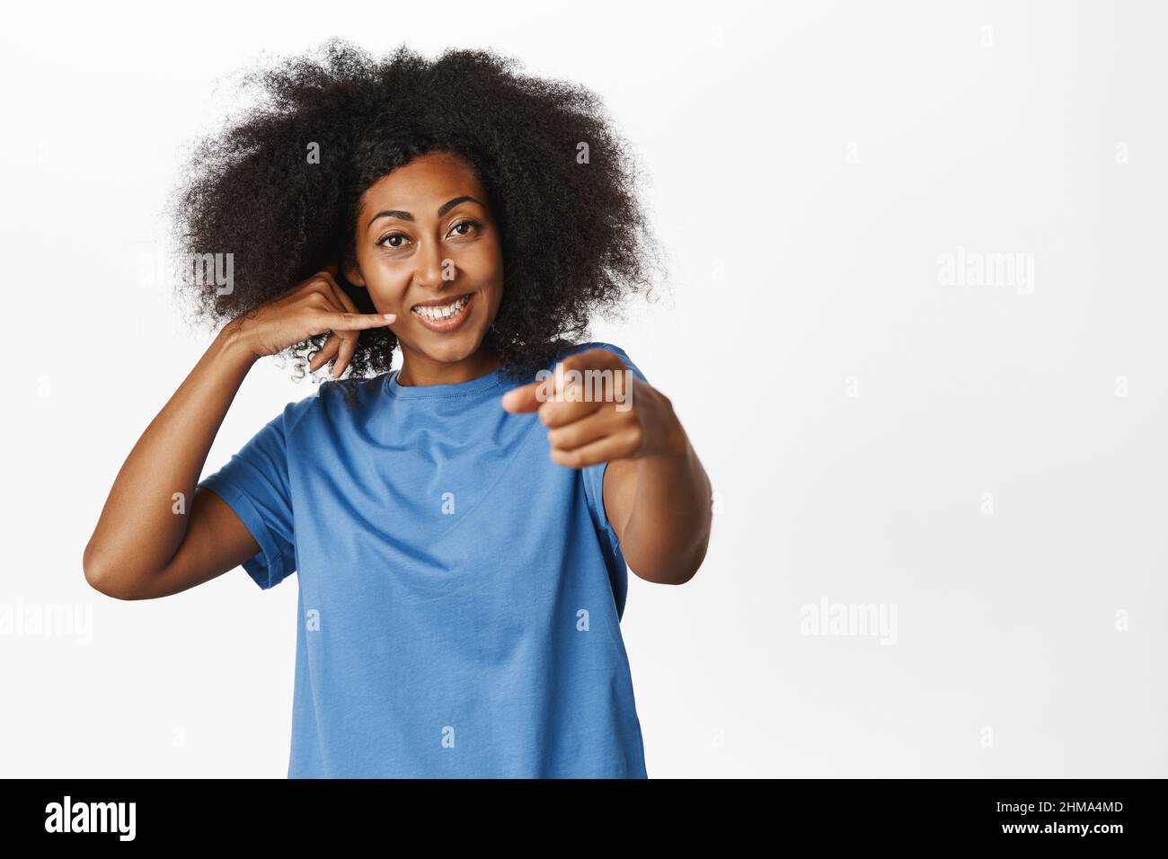 You need to call us. Smiling Black woman pointing finger at camera ...