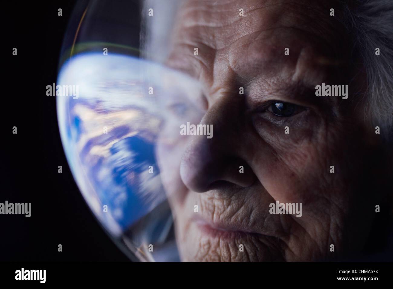 Closeup of concentrated elderly female in spacesuit in space suit ...