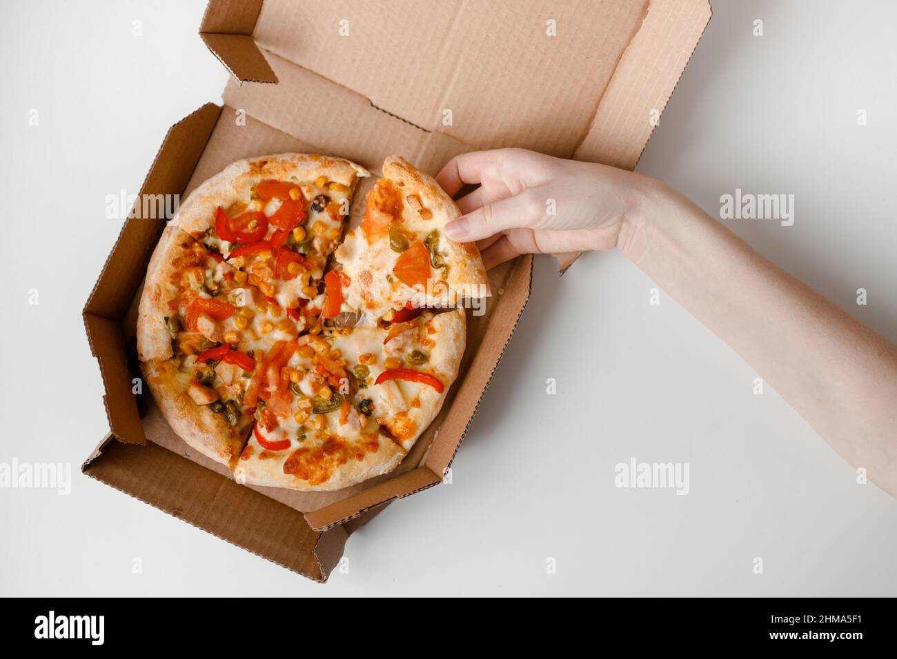 Female hand take piece of mexican pizza in cardboard box for delivery ...