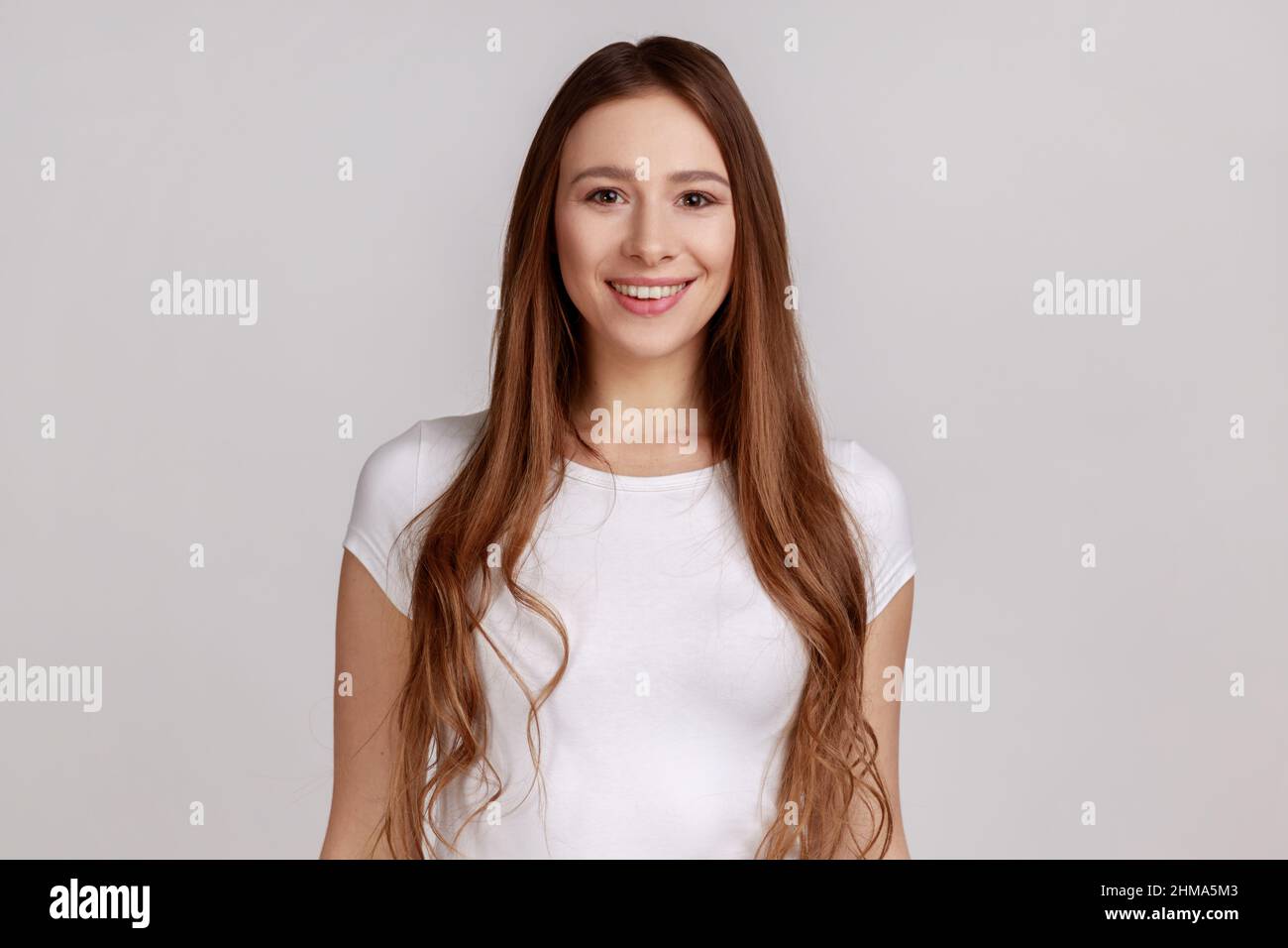 Portrait of beautiful woman with kind look and charming smile, standing ...