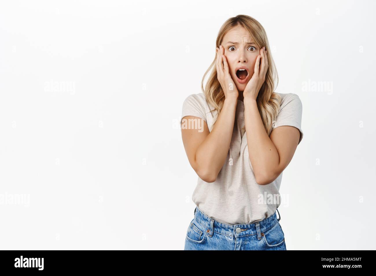 Shocked and scared blond woman staring terrified, horrified of smth ...