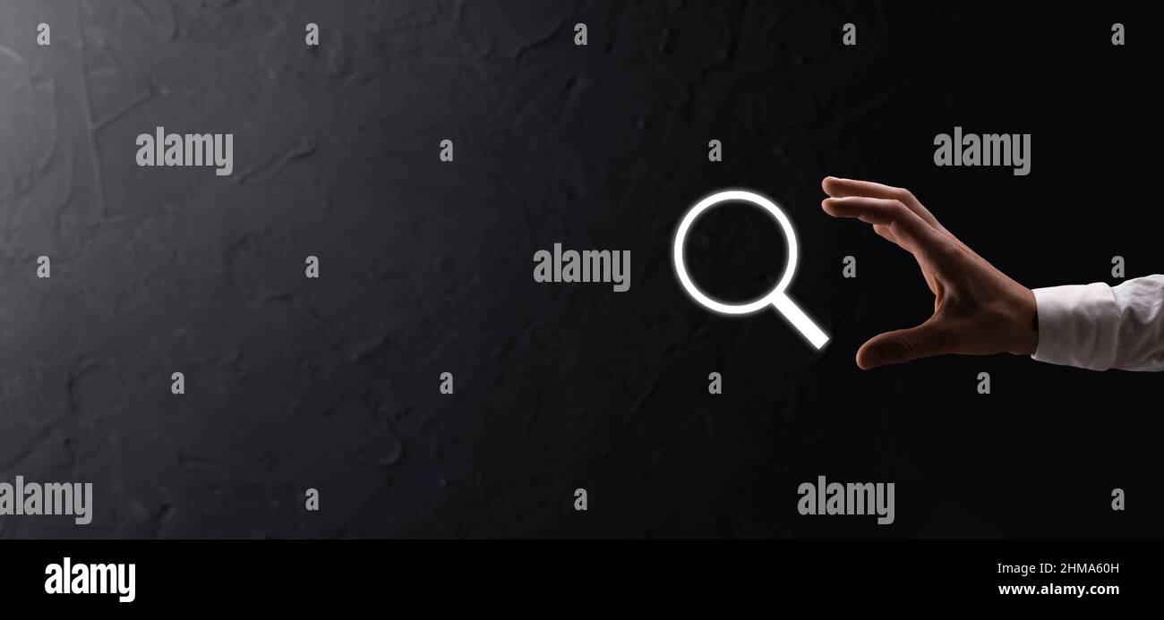 Male hand holding magnifying glass ,search icon on blue background ...