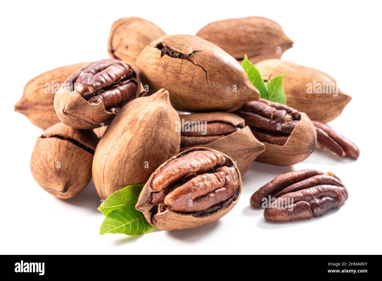 Shelled and cracked pecan nuts with leaves close-up on white background ...