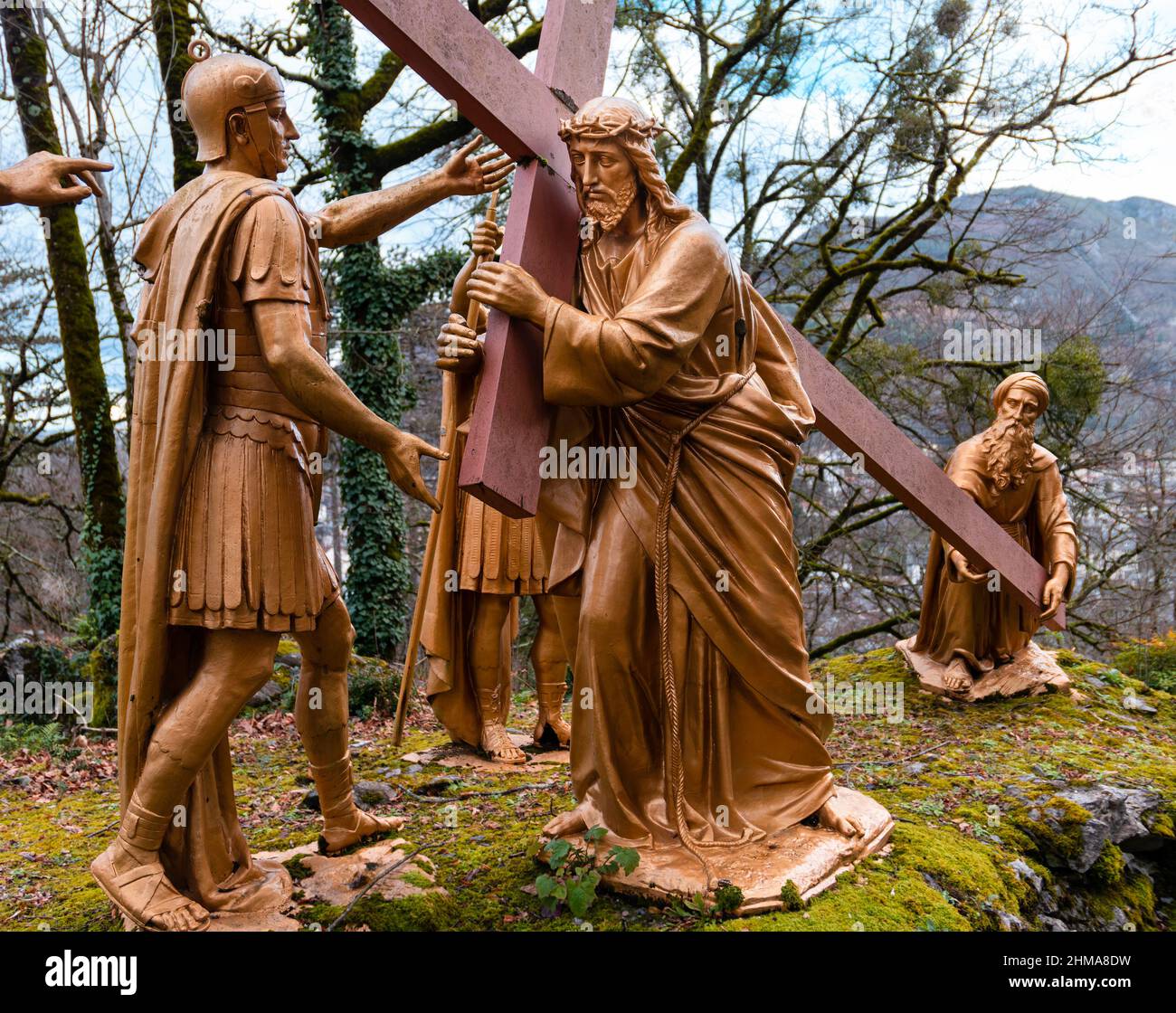 Lourdes, France - January 5, 2022: Way of the cross of Lourdes - fifth station: Simon of Cyrene ...