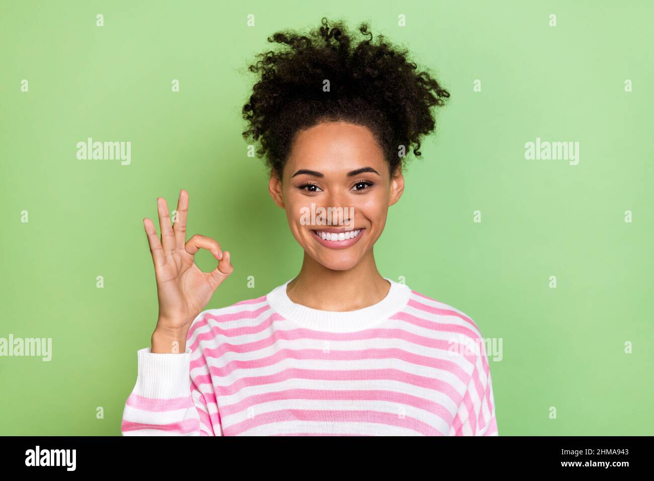 Photo of pretty charming woman wear striped sweater showing okey sign ...