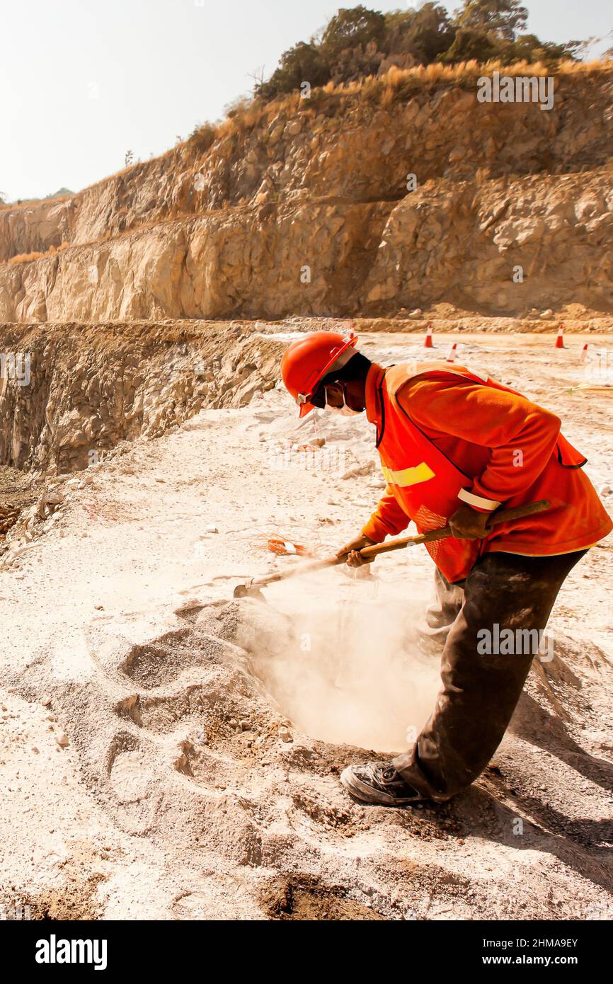 An identified miner wearing a face mask, helmet, and protective ...