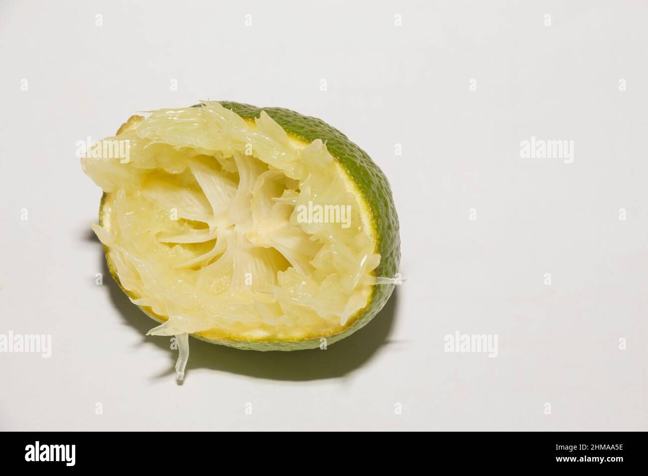 Squeezed half lemon on white background Stock Photo - Alamy