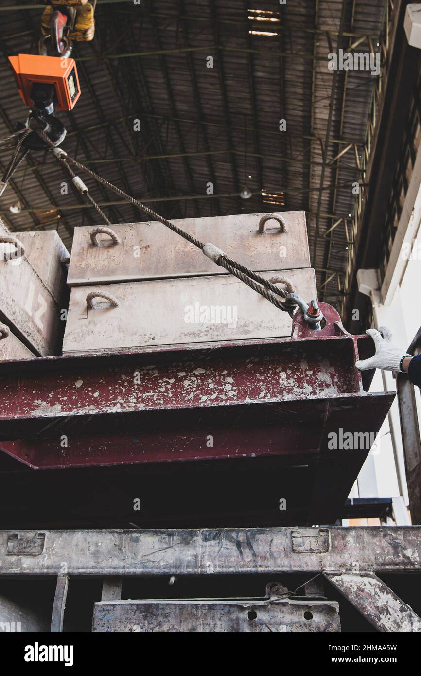 A workman's hands in a glove controlling electric cable hoist, heavy ...