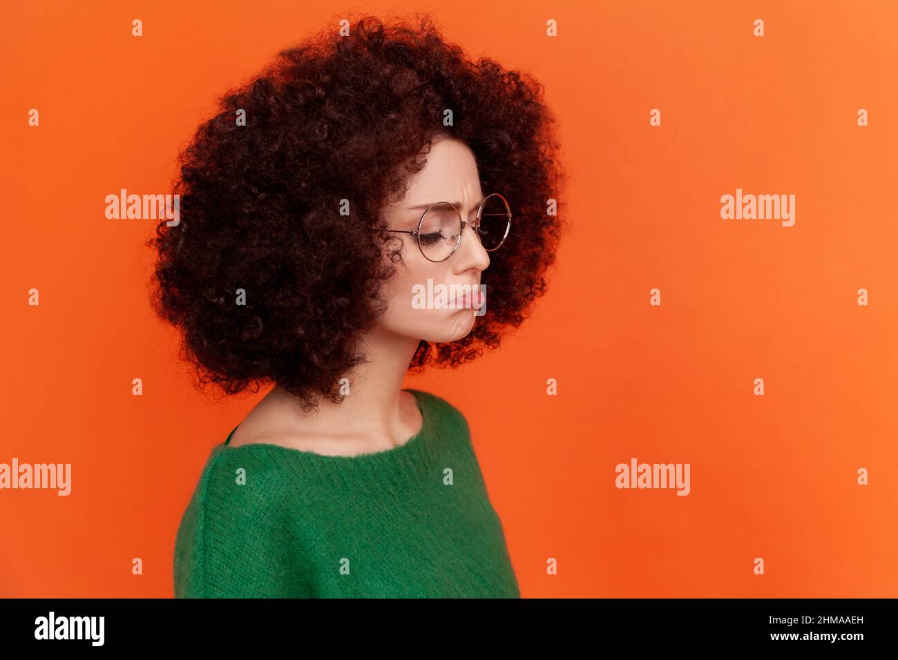 Profile portrait of sad upset woman with Afro hairstyle wearing green ...