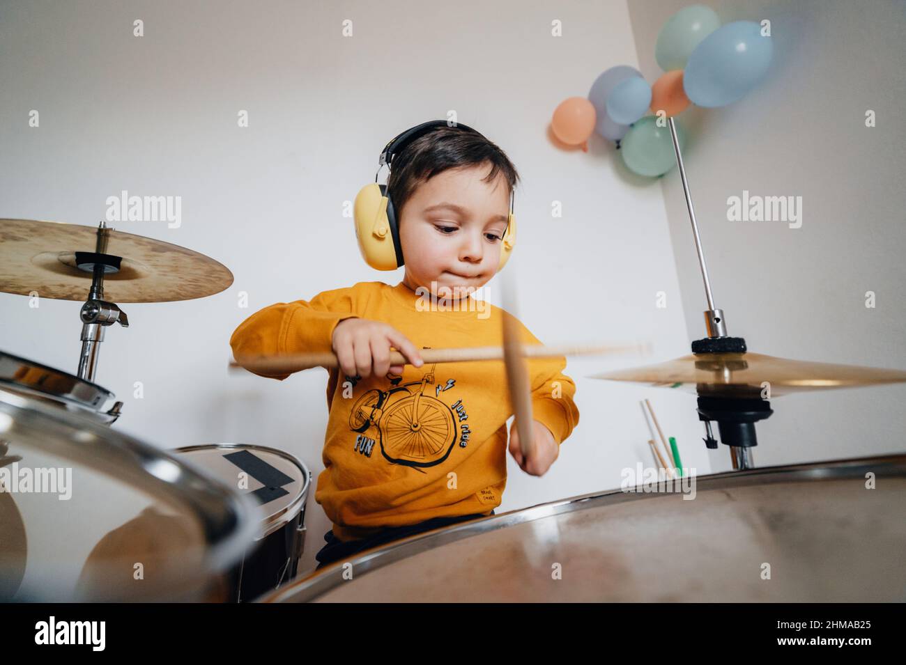 Excited Little drummer learning how to play drums Stock Photo - Alamy