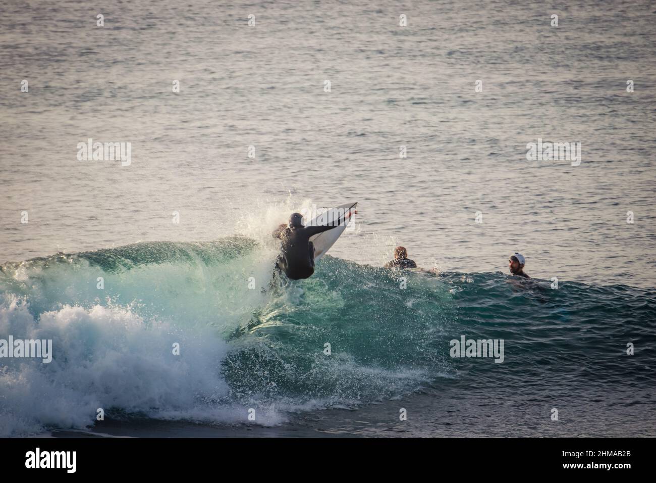 Surfer makes a maneuver in a perfect wave at the sunset Stock Photo - Alamy