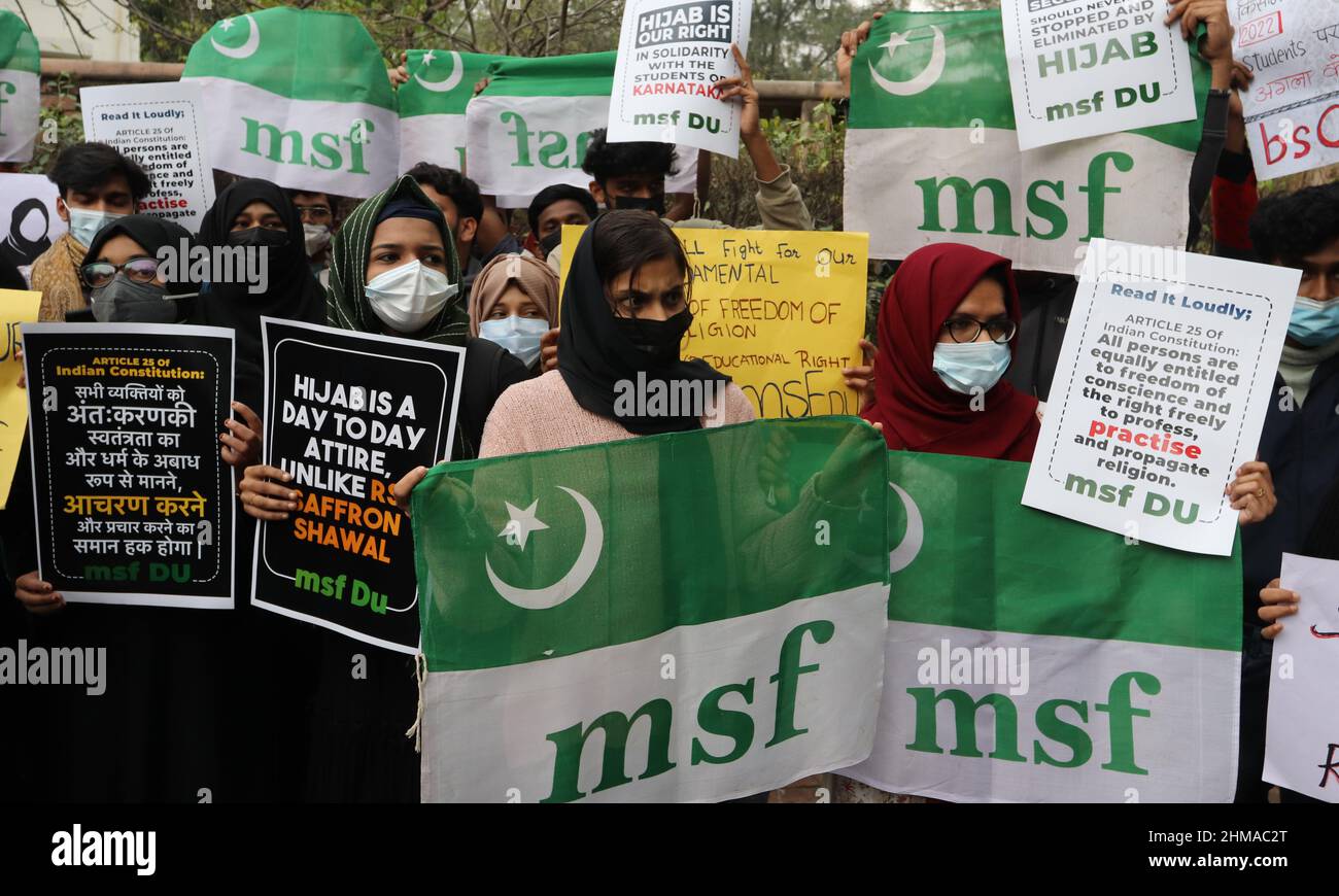 Indian Muslim student activists wearing facemasks hold placards and ...
