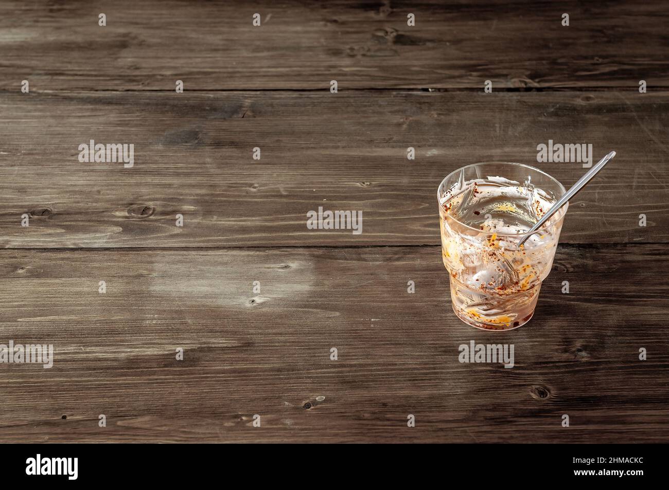 An empty dessert profiterole cup with spoon on a brown wooden table ...