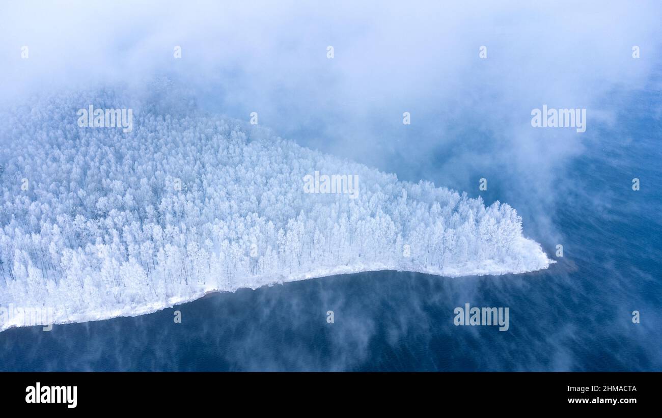 Panoramic aerial view of the winter snow covered forest island and ...