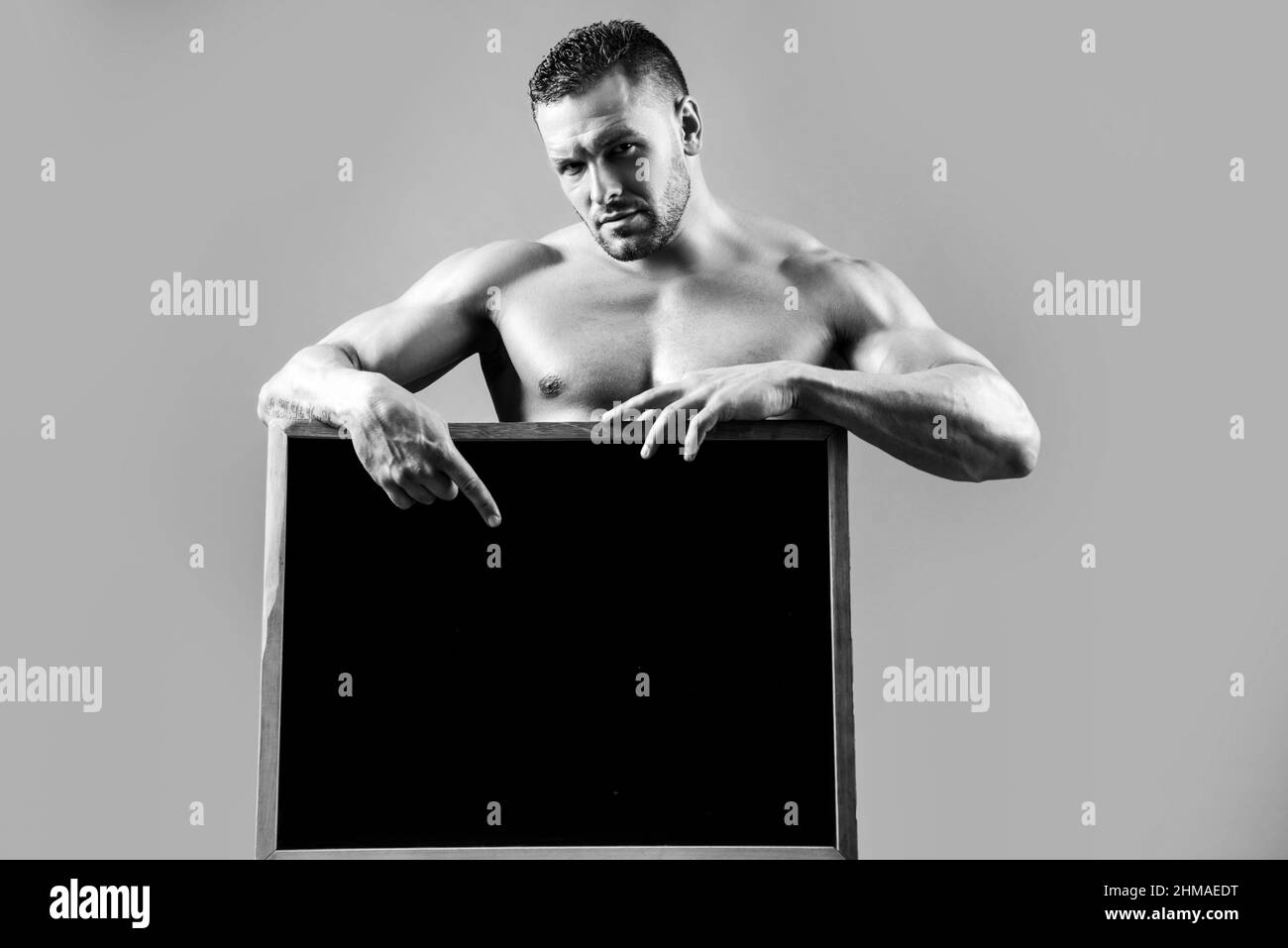 Handsome bodybuilder man with sign advertising board. Strong muscular ...