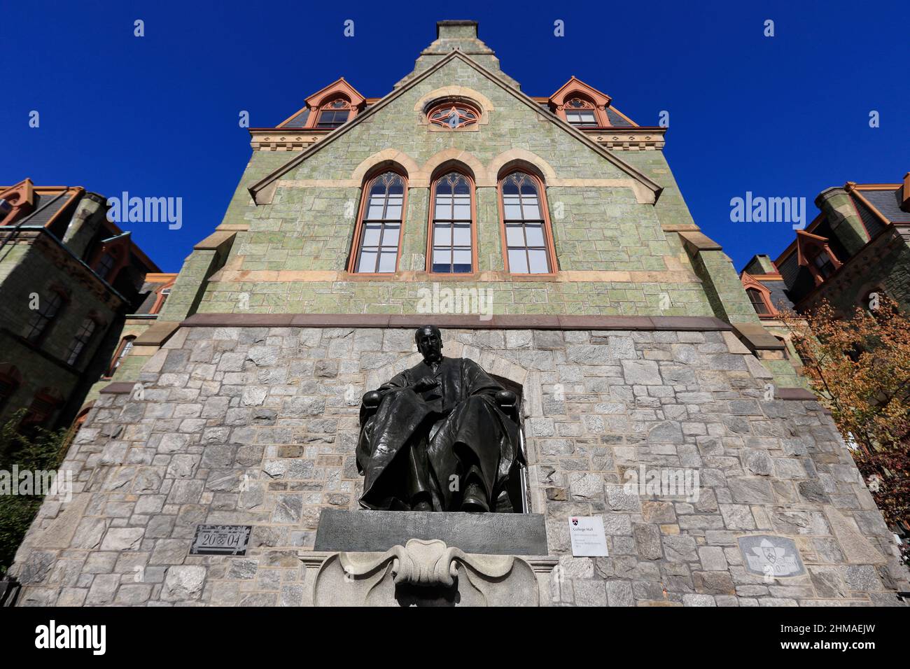 The low angle view of Victorian Gothic College Hall with the statue of ...