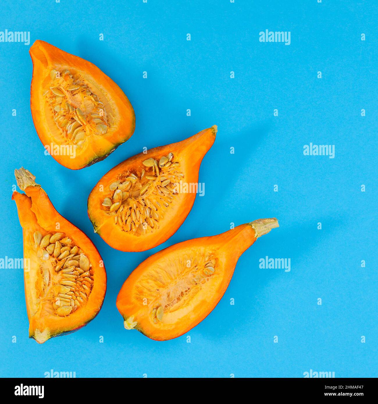 Sliced ripe organic orange pumpkin on cyan background. Creative food ...