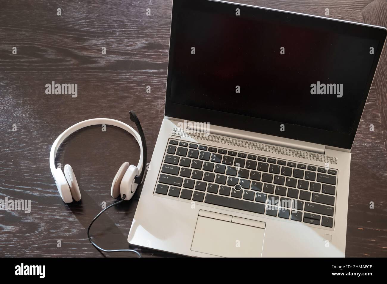 Headset on a laptop, blank screen, wooden table background, Call center ...