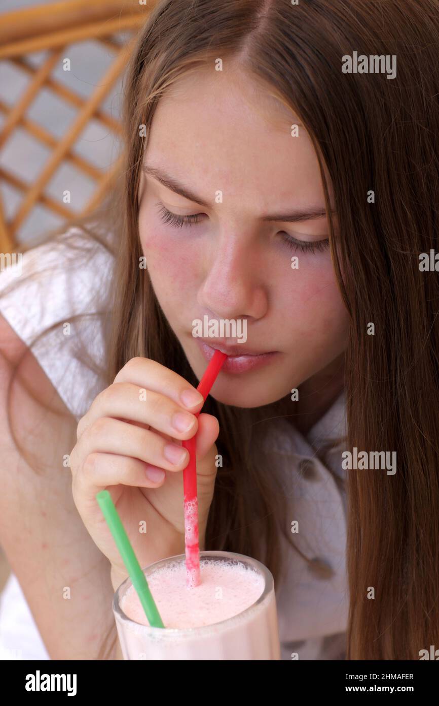 The teen drinks milk strawberry shake at the cafe Stock Photo - Alamy