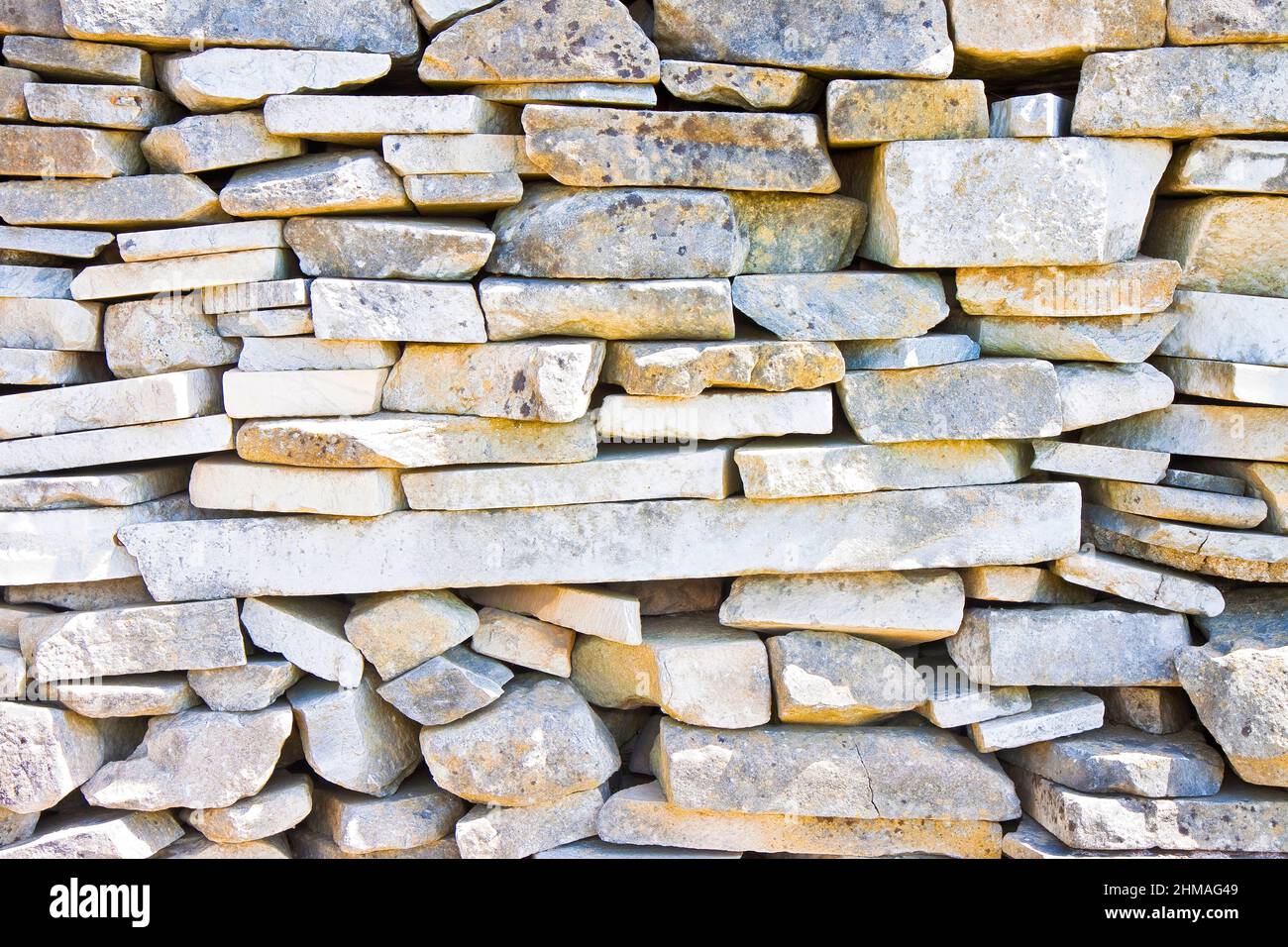 Stone wall built with blocks and marble slabs simply placed over one ...