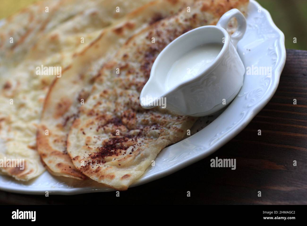 Cuisine of Azerbaijan - Kutaby with white sauceboat Stock Photo - Alamy