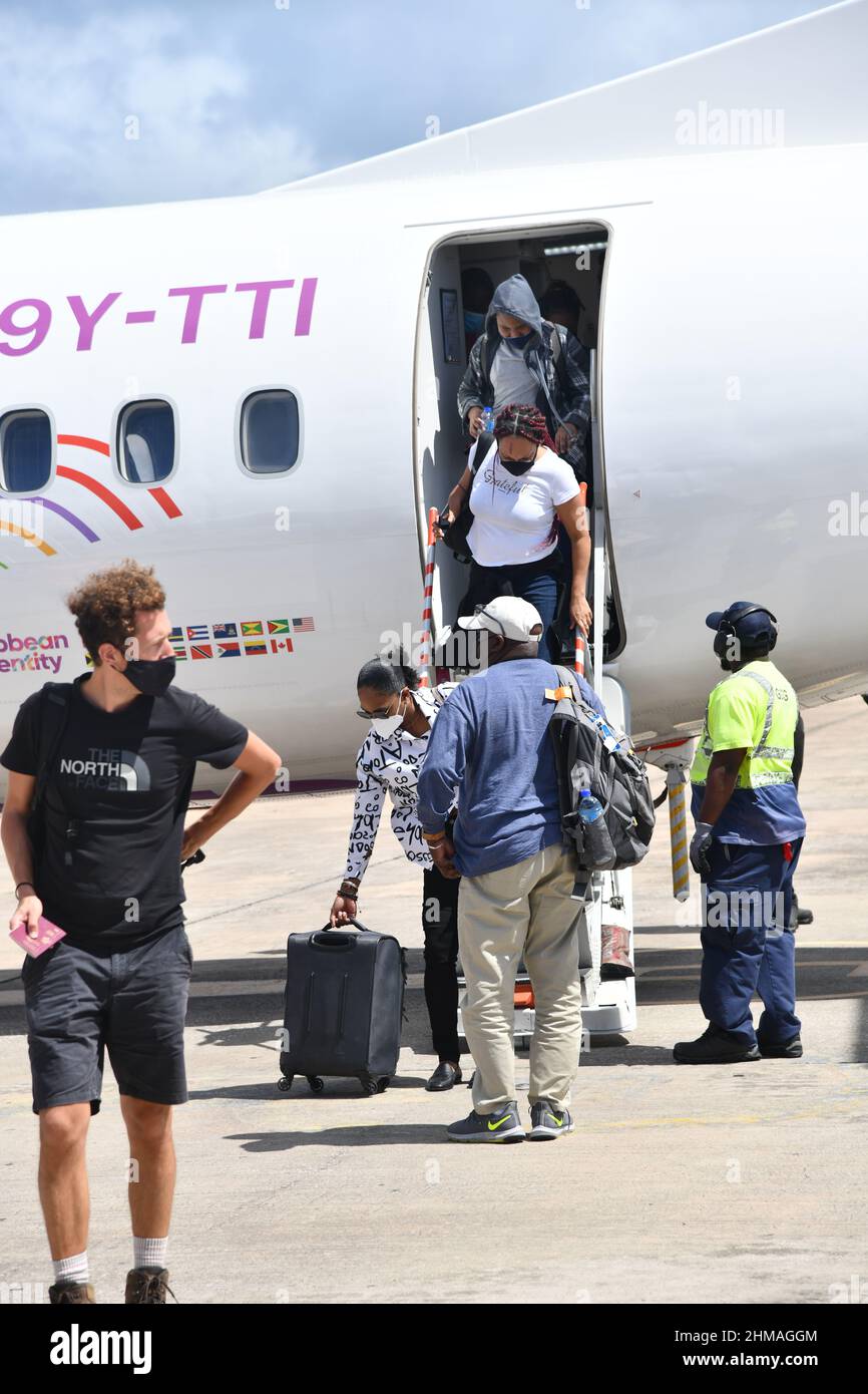 Passengers disembark airplane wearing facemasks during covid 19 ...