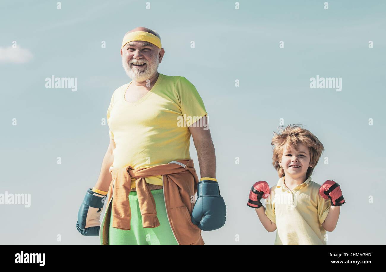 Older - young man boxing. Handsome elderly man practicing boxing kicks ...