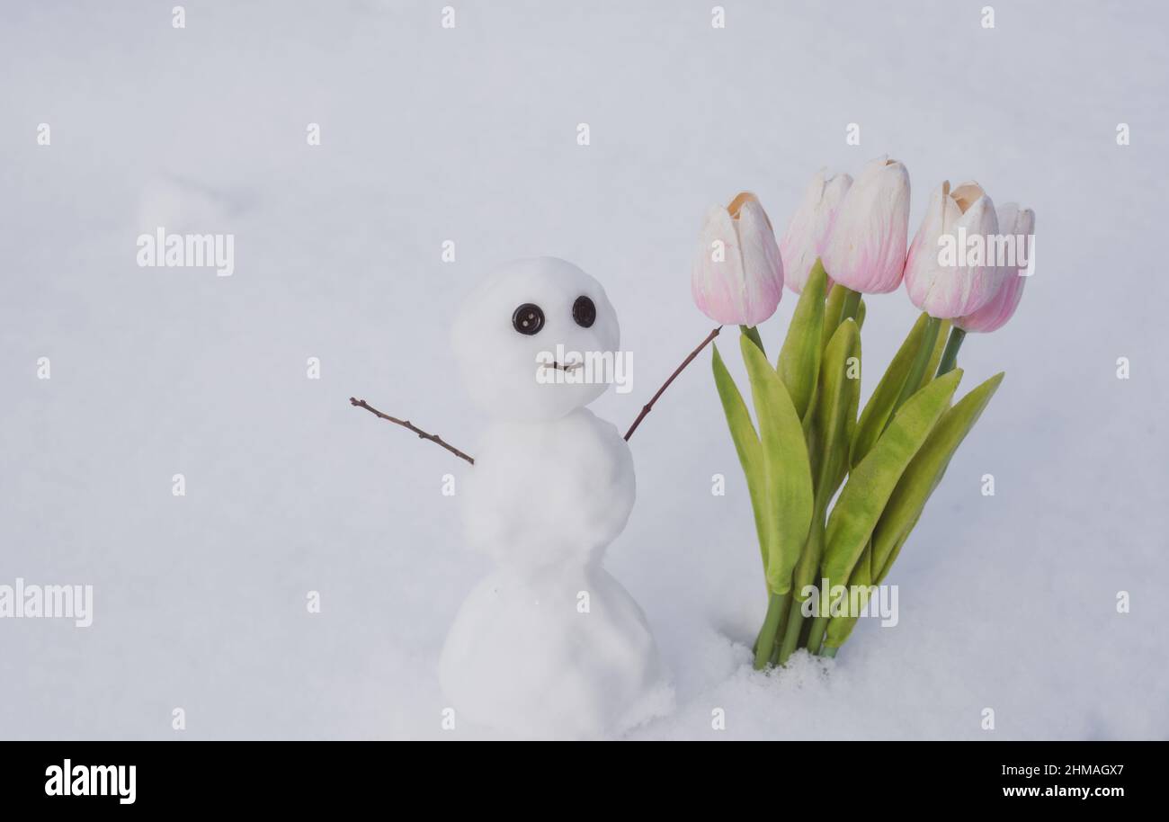 Snowman with spring tulip flowers. Winter snow man with stick hand ...