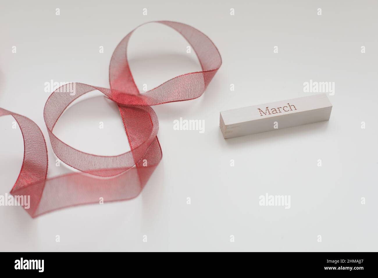 8 March, International Women's Day concept. Red ribbon and word MARCH ...
