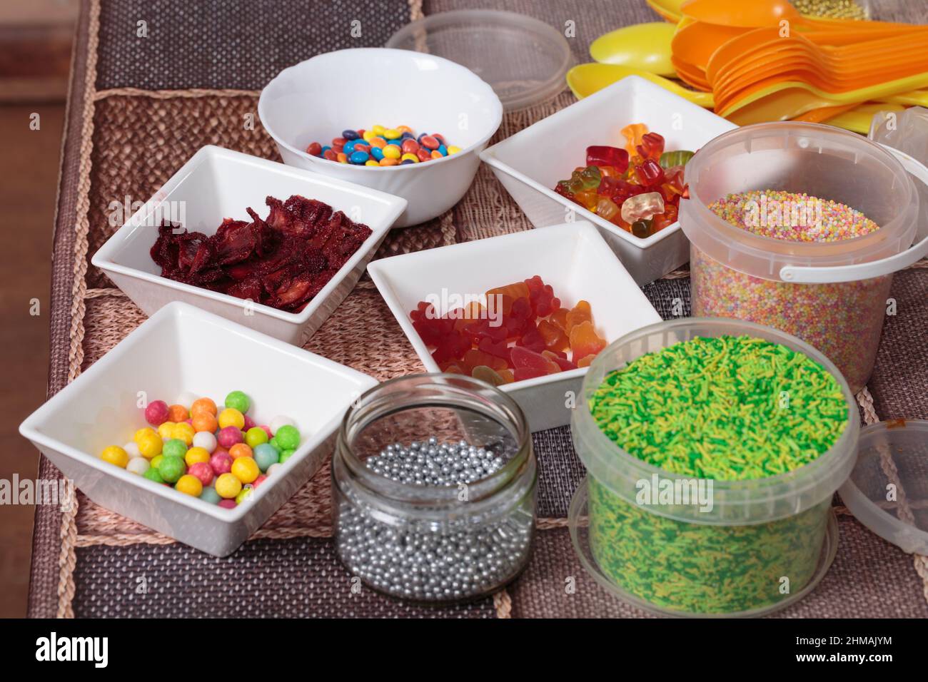 Set of colorful sugar dragee and sprinkles. It is on a table covered ...