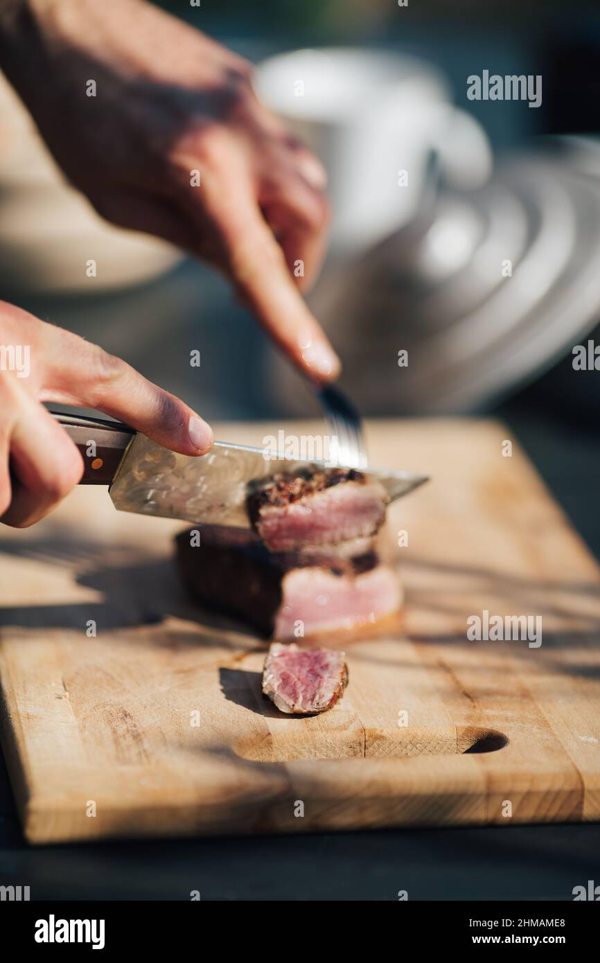 Selection of medium rare steaks, cut with knife with potato wedges as ...