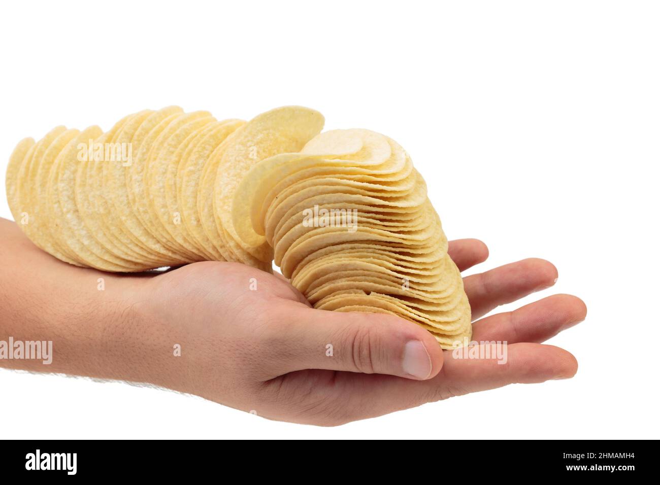 A human hand holds a fallen stack of potato chips. It is isolated over ...