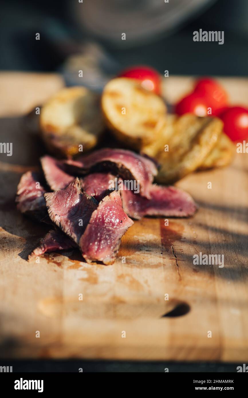 Selection of medium rare steaks, cut with knife with potato wedges as ...