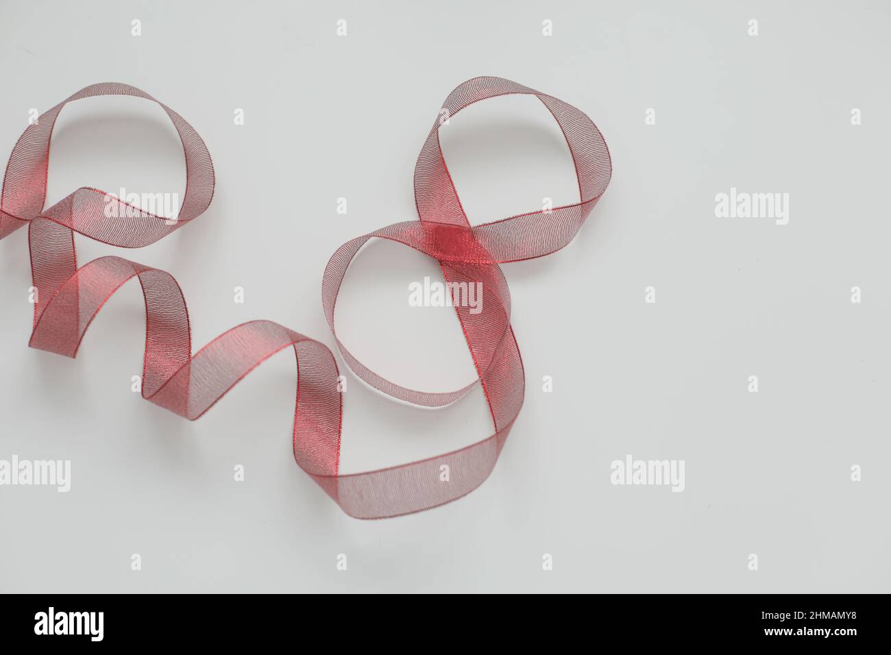 Figure eight of red ribbon on white background Stock Photo - Alamy