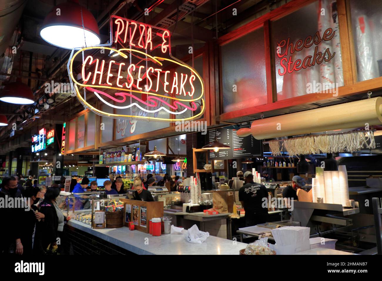 Neon sign of Pizza & Cheesesteaks over a food vendor's counter in ...