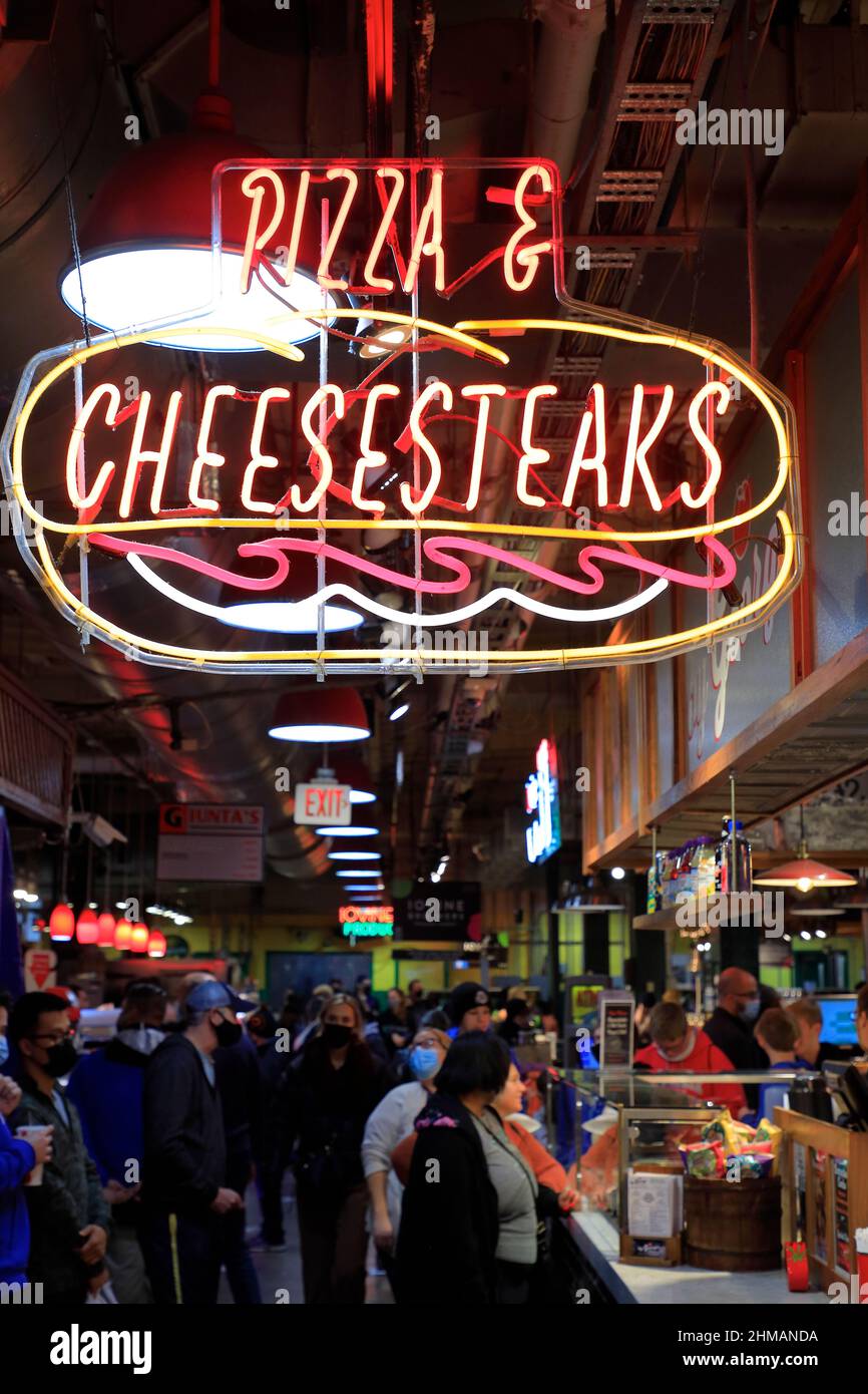 Neon sign of Pizza & Cheesesteaks over a food vendor's counter in ...