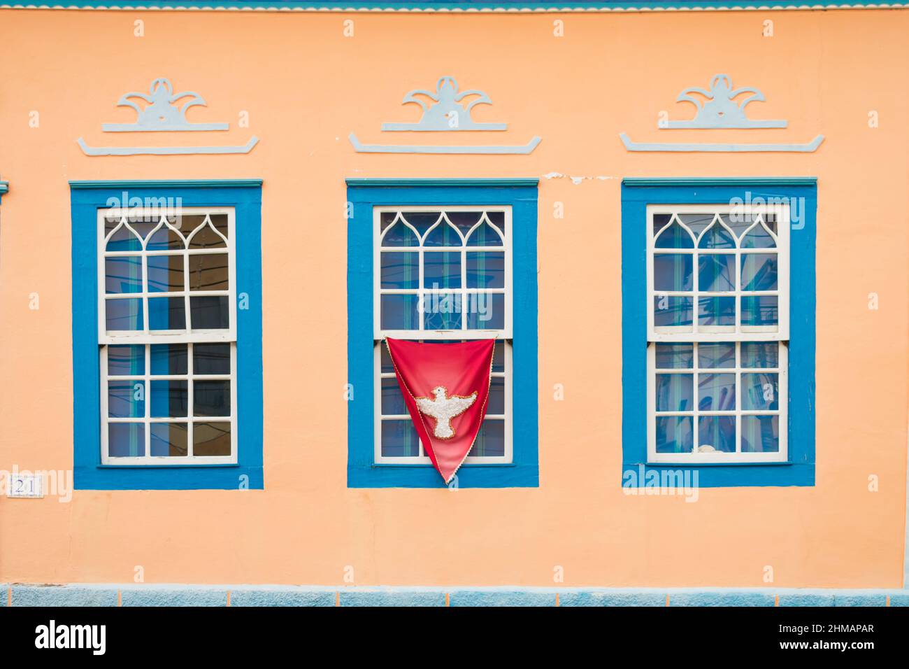 Holy Spirit flag, red with a white dove, on the window of a historic ...
