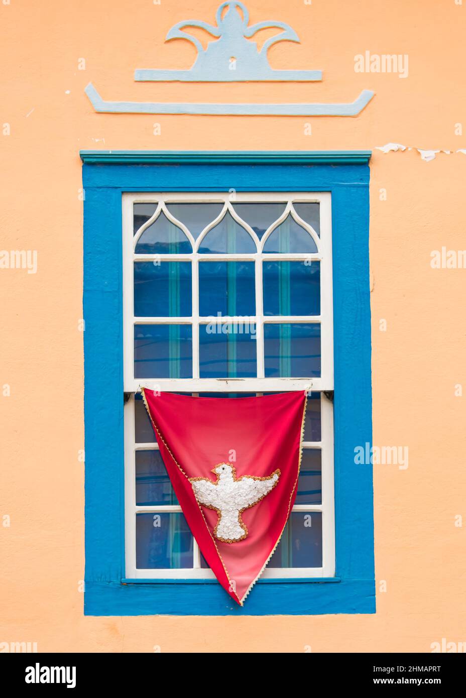 Holy Spirit flag, red with a white dove, on the window of a historic ...