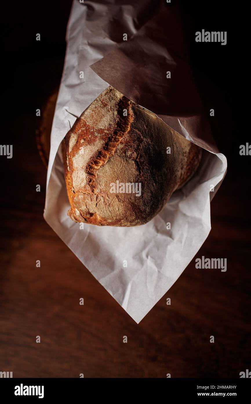 Tasty french bread in paper from bakery Stock Photo - Alamy