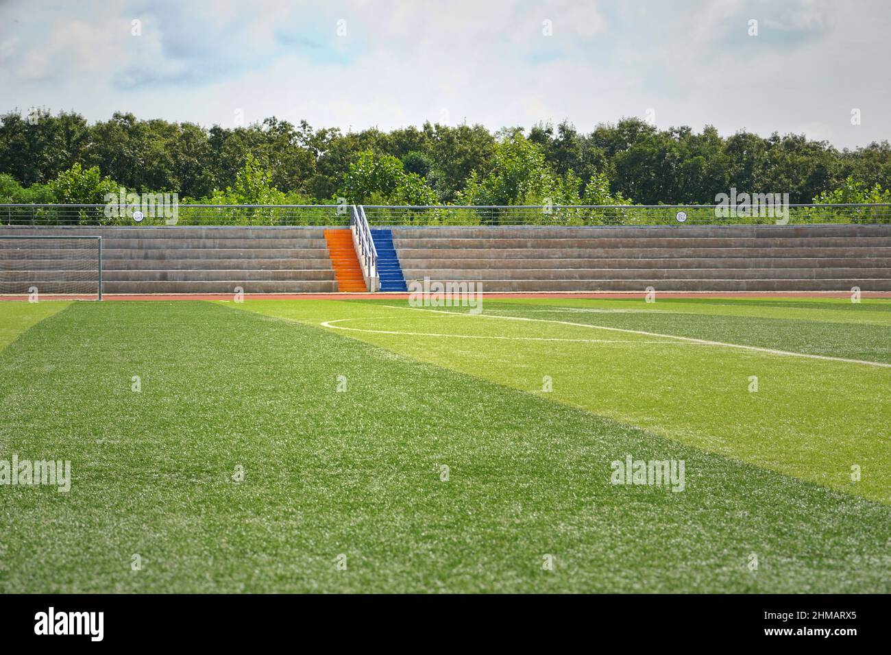 Green football field with concrete seats Stock Photo - Alamy