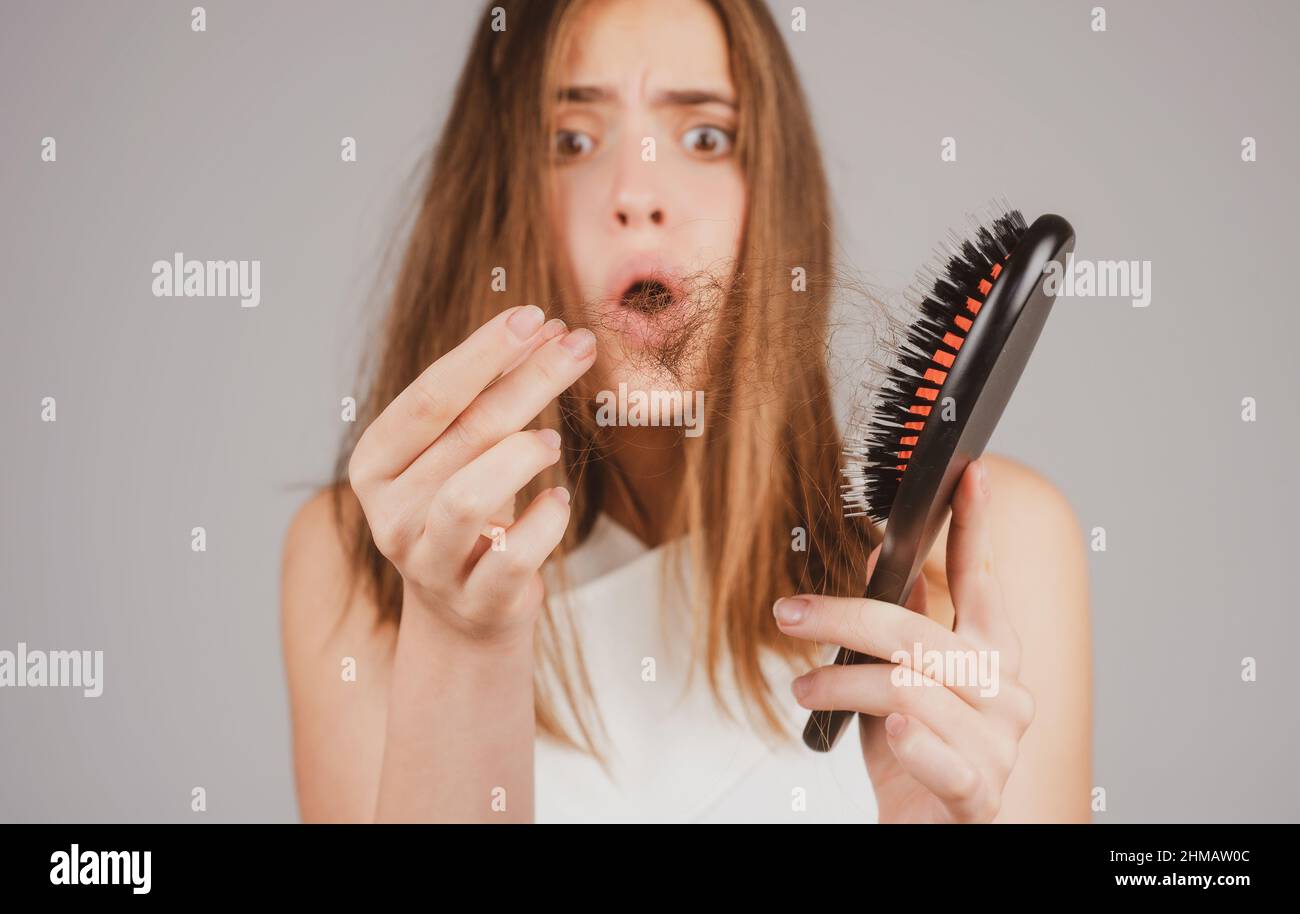 Sad girl looking at damaged hair, the hair loss problem. Isolated, copy ...