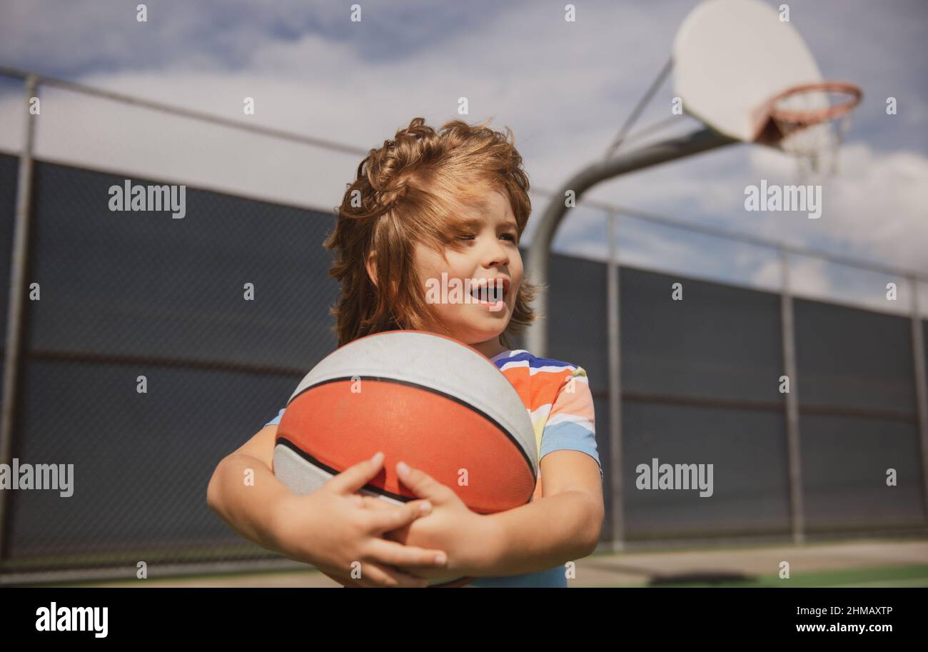 Little caucasian sports kid playing basketball holding ball with happy ...