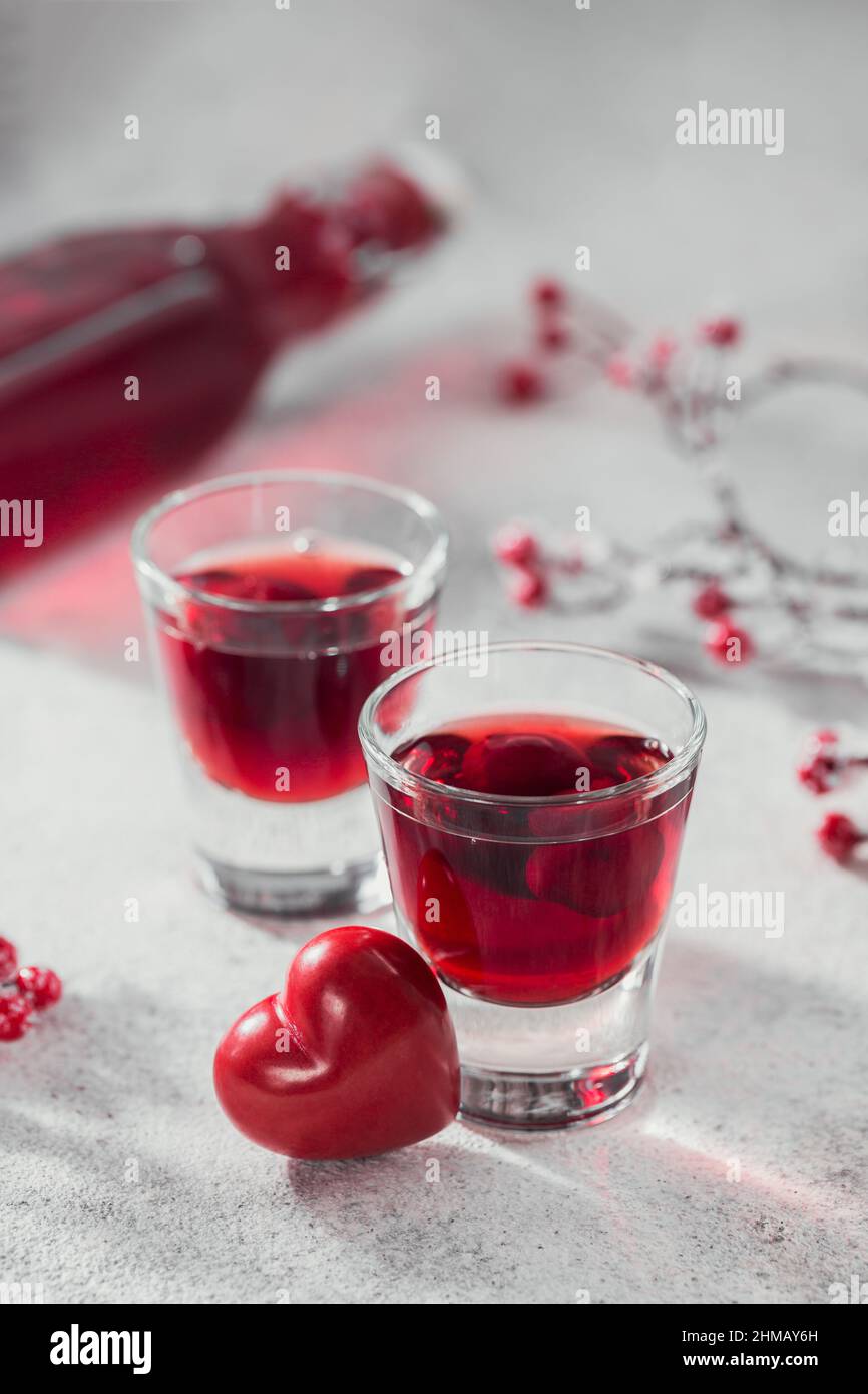 Red cocktail, vodka or liqueur and Heart shape decorations on white ...