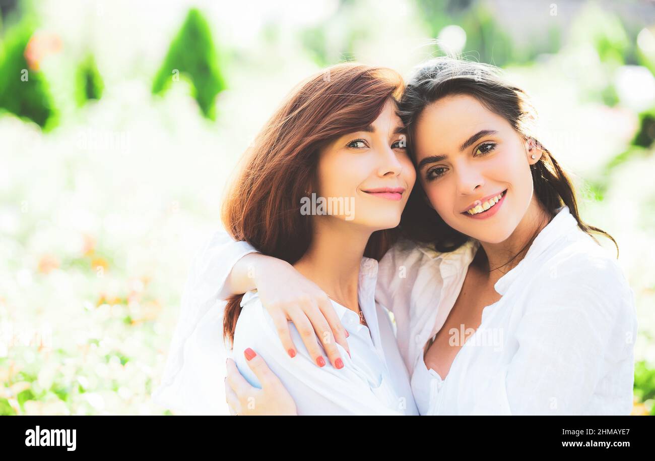 Portrait of young women standing together and looking at camera over ...