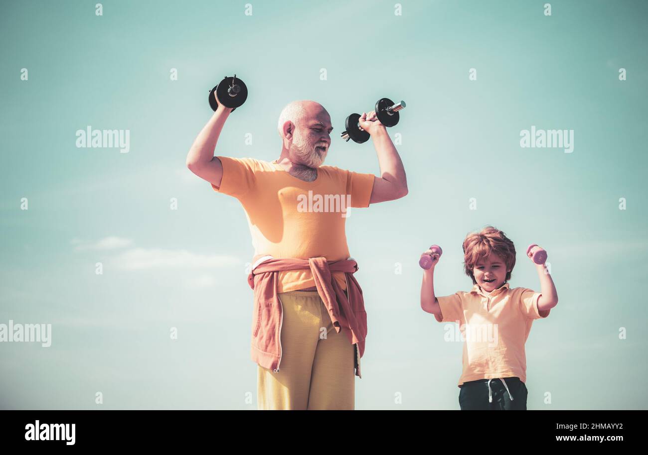Portrait of senior man and cute child lifting dumbbells. I love sport ...