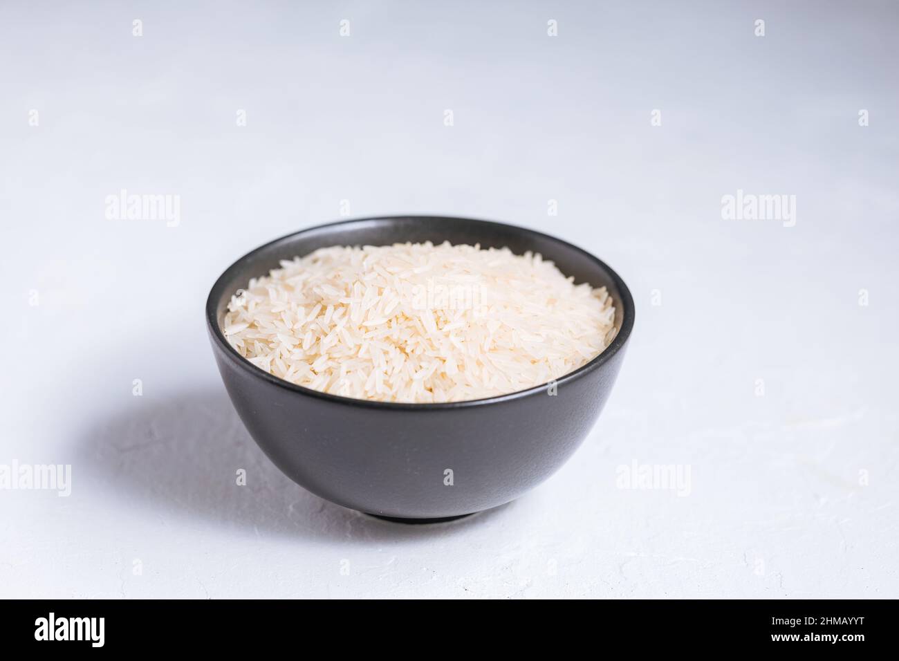 Basmati rice, cooked and raw in different bowls and placed on different ...