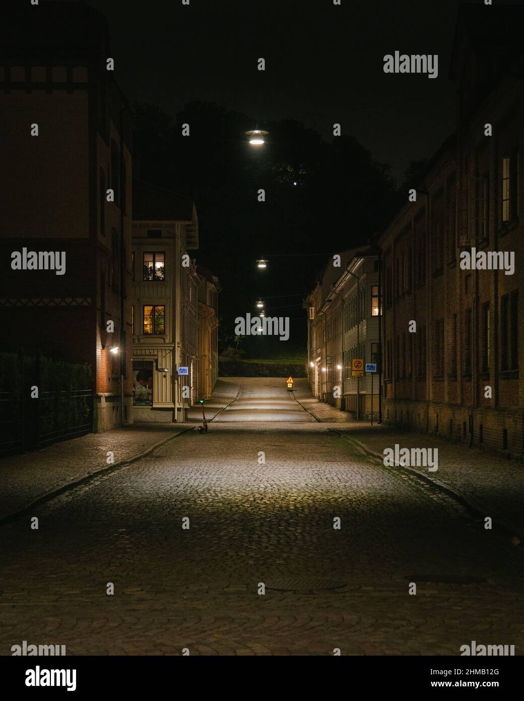 Beautiful night view of an empty urban street with lights on a stone ...