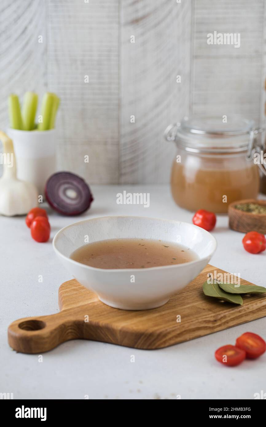 A plate with healthy homemade bone broth on a wooden board. The concept ...